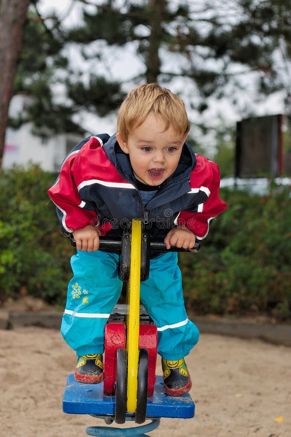 Boy on playground ride stock image. Image of excitedly - 6418691