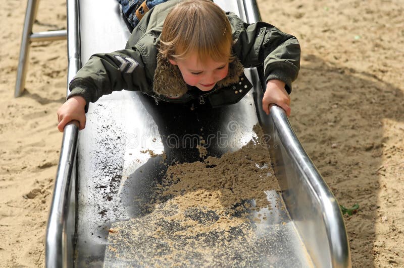 Boy on playground slide stock image. Image of youngster - 2413581