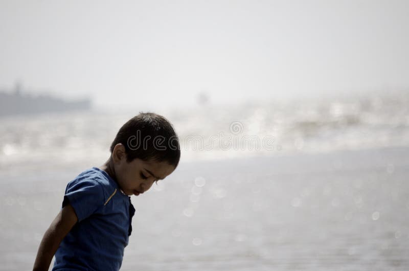 Boy playing on beach sand stock photo. Image of cute - 142309260