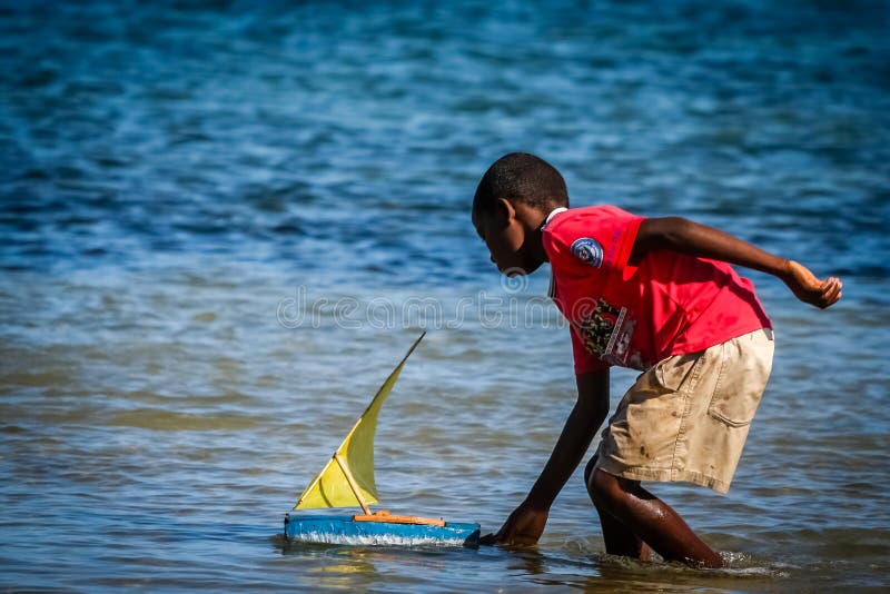 Boy playing with a boat editorial image. Image of beach - 44295035