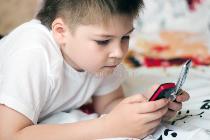 Boy playing on cell phones stock image. Image of mobile - 27686209
