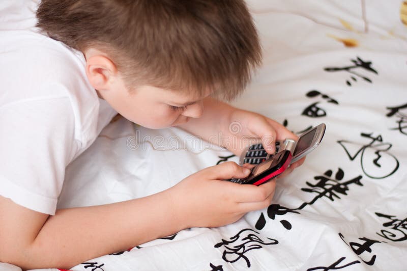 Boy playing on cell phones stock photo. Image of phone - 27686218