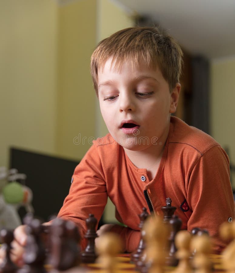 Boy playing chess at home stock photo. Image of activity - 245489624
