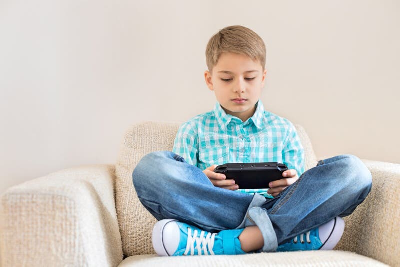 Boy Playing Hand Held Video Game Sofa Stock Photos - Free & Royalty ...