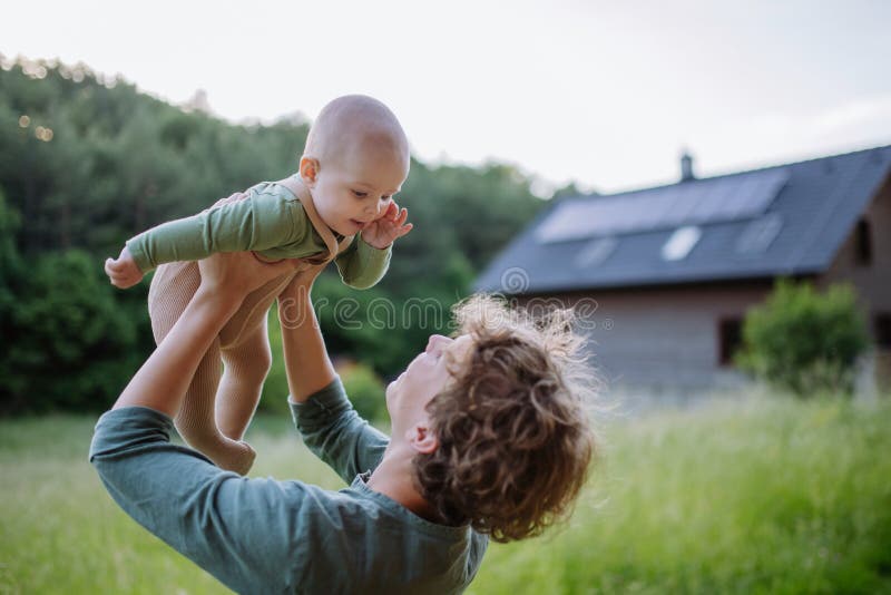 Boy Playing with His Little Brother in Front of Their House with Solar ...