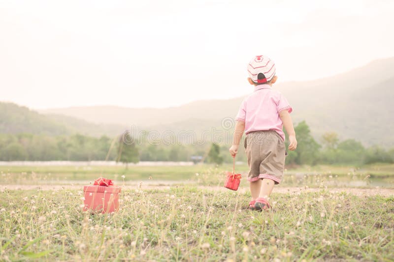 Boy Playing and Holding Gift Box O on Grass Field in Evening Stock ...