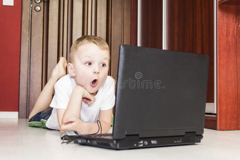 Boy playing laptop stock image. Image of emotion, surprise - 73048339