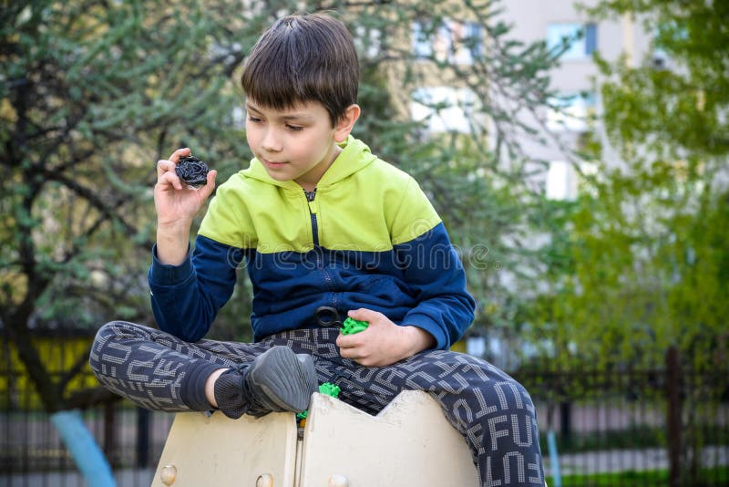 Boy Playing with Modern Spin Top Outdoors. Entertainment Game for ...