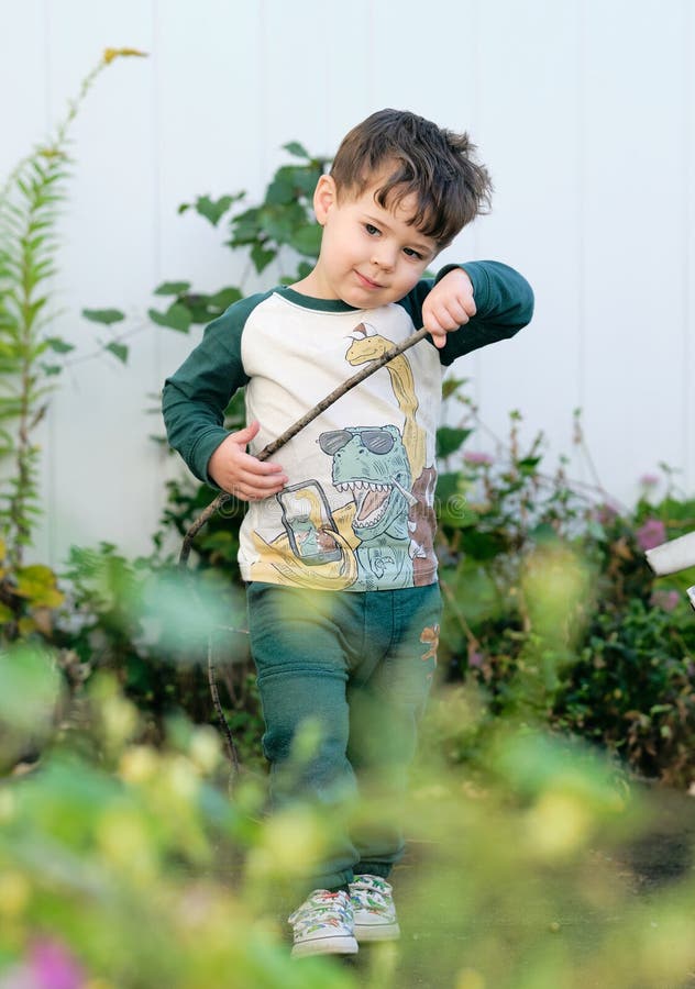 Little Boy Playing with a Twig in the Garden Stock Image - Image of ...