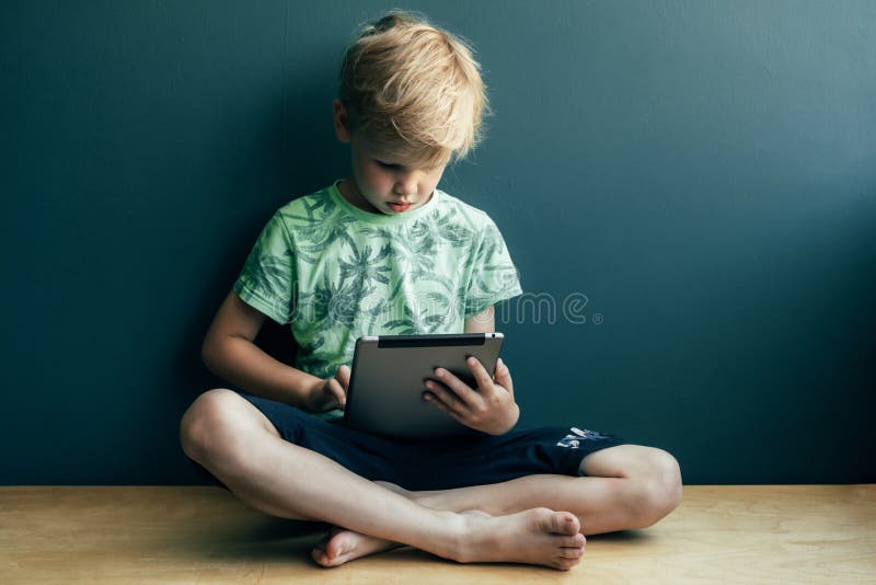Boy playing on tablet stock photo. Image of community - 189416964