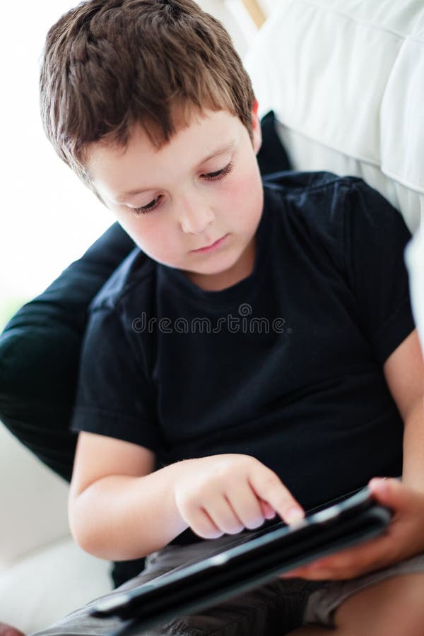 Boy playing on a tablet stock photo. Image of sitting - 35212884