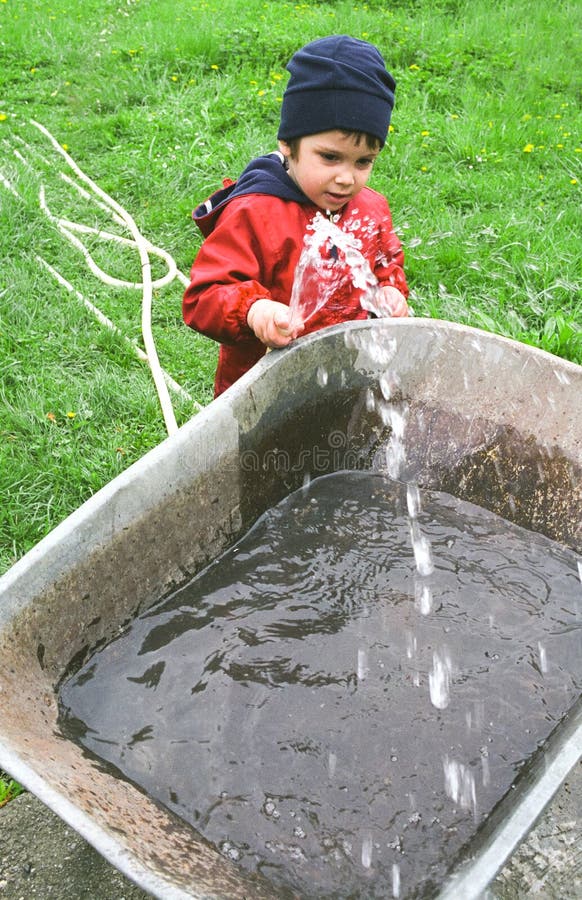 Boy playing with water stock photo. Image of watering - 21753872