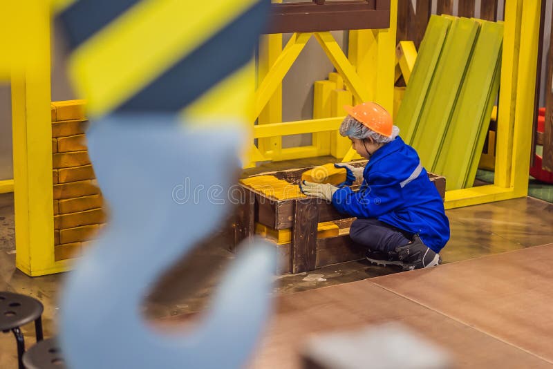 A Boy Plays in the Builder in Construction Clothes and a Helmet Stock ...