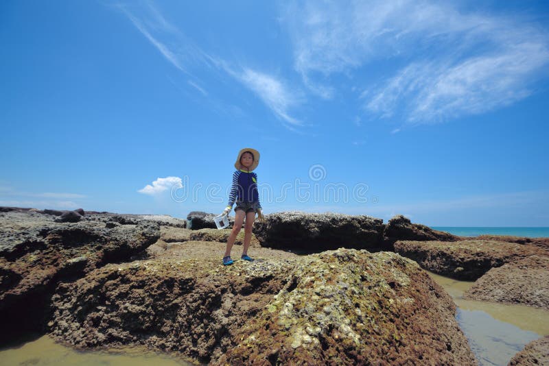 A Boy Plays Exploring at the Beach Rocks. Stock Image - Image of ...