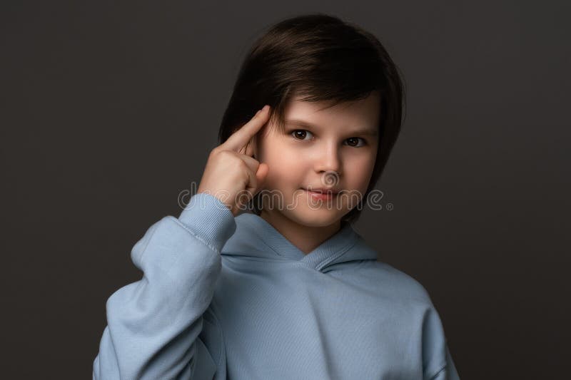 Boy Pointing with Finger at Head, Showing this Gesture the Seriousness ...
