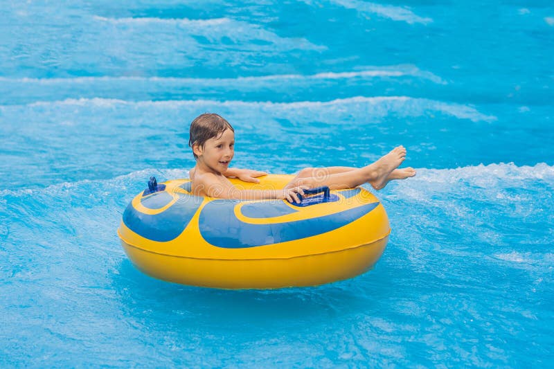 Boy on a Pool Float on Artificial Waves in a Water Park Stock Photo ...