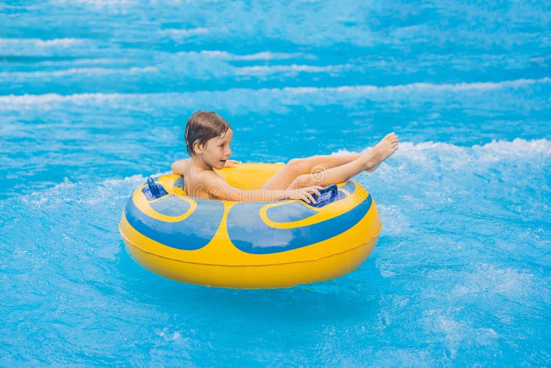 Boy on a Pool Float on Artificial Waves in a Water Park Stock Image ...