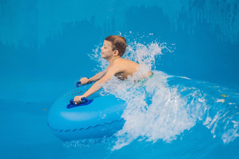 Boy on a Pool Float on Artificial Waves in a Water Park Stock Photo ...