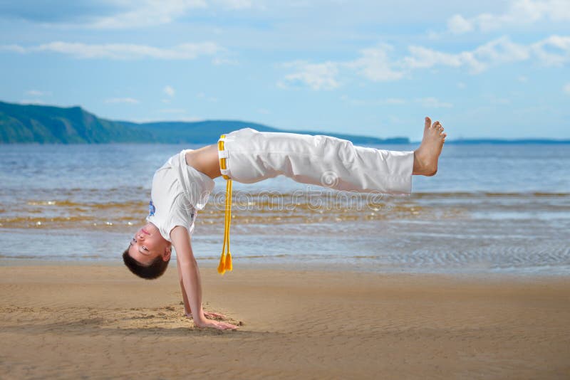 Boy Practicing Capoeira on the Beach. Guy Performs a Handstand. Stock ...