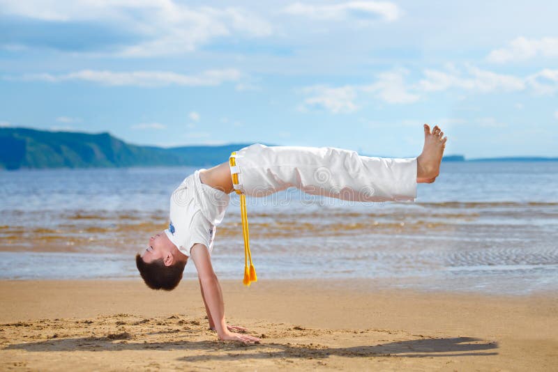 Boy Practicing Capoeira on the Beach. Guy Performs a Handstand. Stock ...