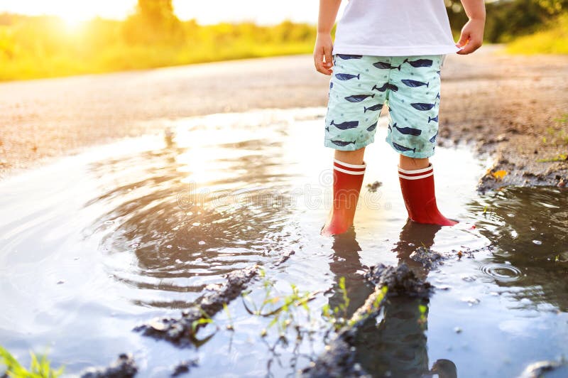 Boy in a puddle stock image. Image of spring, green, outside - 50906371