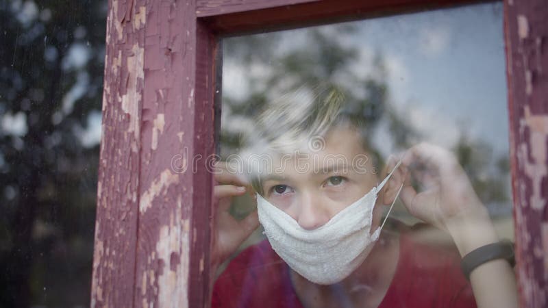 Boy at Home Look at the Window and Puts on a Mask before Going Outside ...