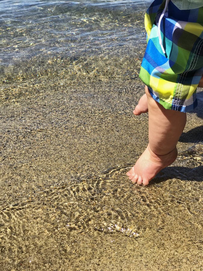 Boy putting toes in water stock photo. Image of child - 96295422