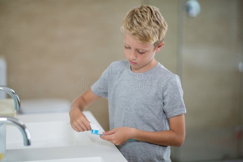 Boy Putting Toothpaste on Sister Toothbrush in Bathroom Stock Image ...