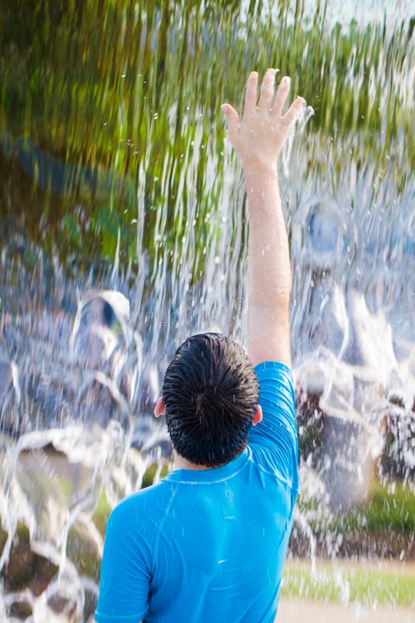 Boy Reaching Up To Feel Water in a Waterfall Stock Image - Image of ...