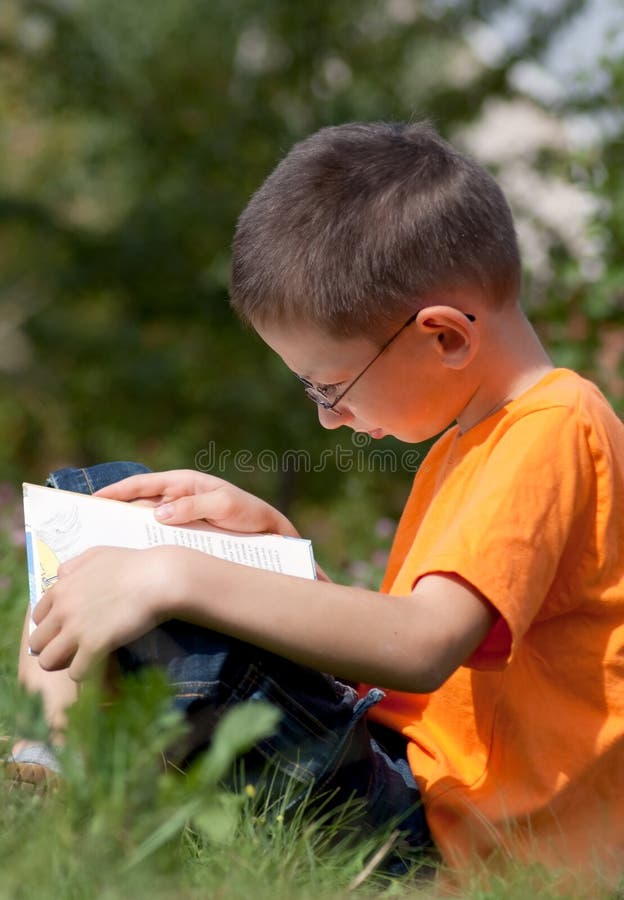 Boy reading a book stock image. Image of outdoor, green - 14815807