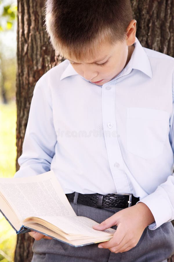 Boy reading book stock image. Image of wear, park, tree - 16250675