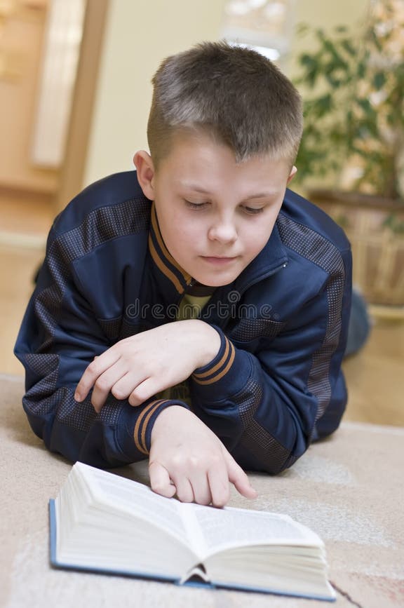 Boy reading book on carpet stock photo. Image of reading - 4712998