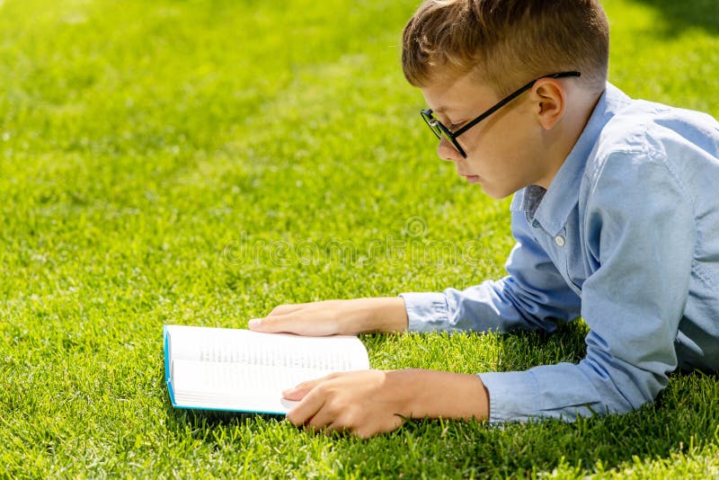 A Boy Reading a Book on a Grass Stock Photo - Image of rejuvenation ...