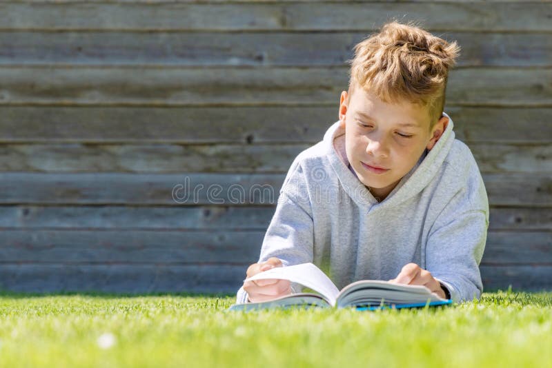 A Boy Reading a Book on a Grass Stock Image - Image of literature ...
