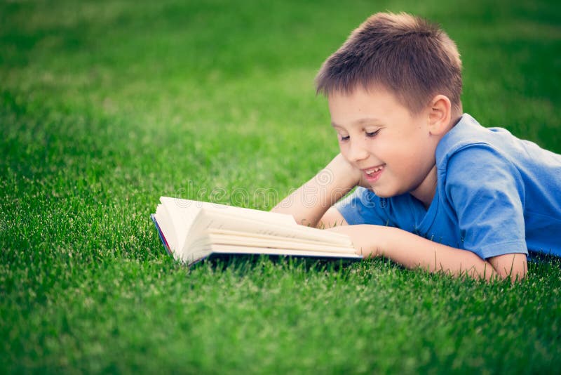 Boy Reading Book on Green Grass Stock Photo - Image of reading, focus ...