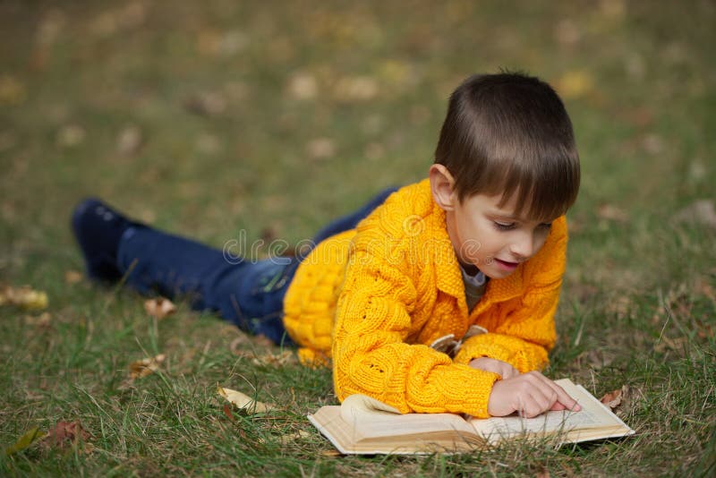 Boy Reading Book Lying on the Grass Stock Photo - Image of happy, book ...