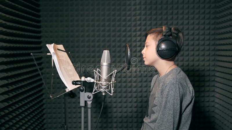 A Boy is Recording a Song in a Recording Studio. the Boy in the ...