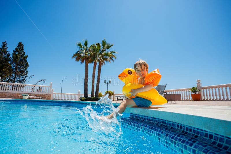 Boy at Resort Pool Enjoys Summer, Splashing in Buoy and Floaties Stock ...