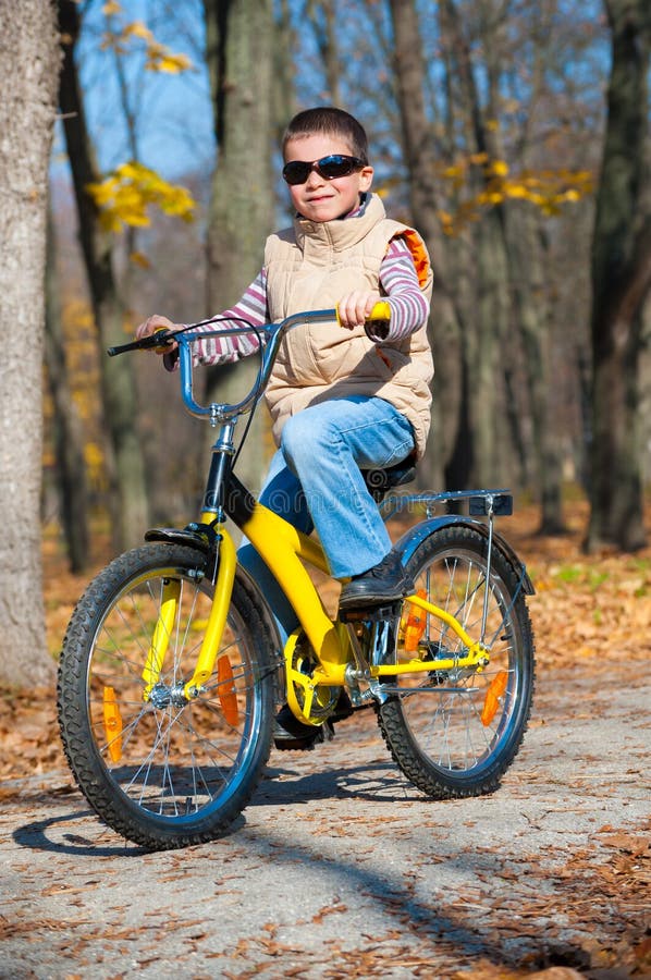 Boy Rides a Bicycle in Park Stock Image - Image of happy, jeans: 34786337