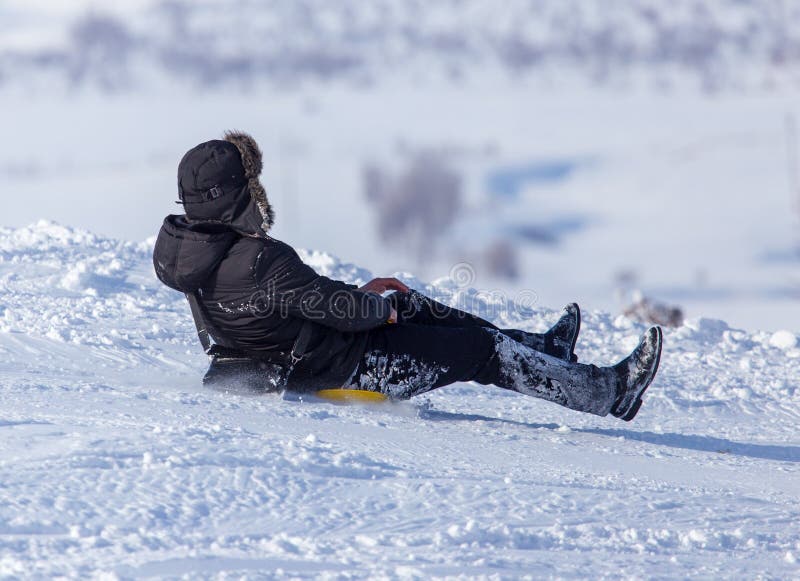 The Boy Rides a Sled from the Mountain in Winter Stock Photo - Image of ...