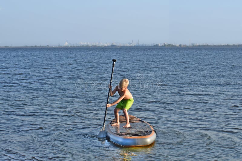 A boy rides a SUP stock image. Image of holiday, adventure - 333672031
