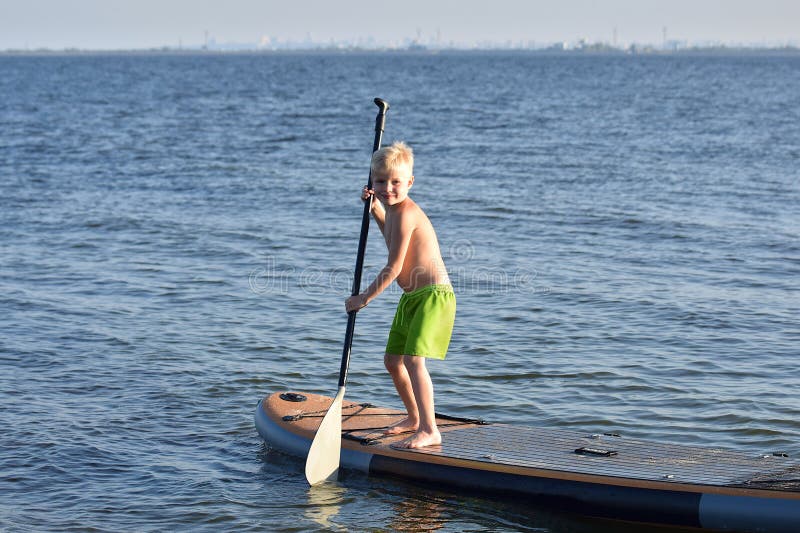A boy rides a SUP stock photo. Image of holiday, adventure - 335953784