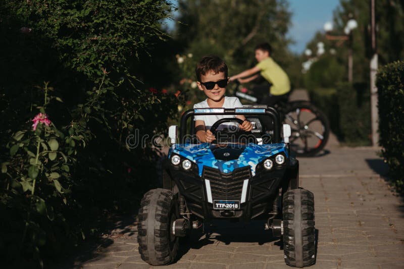 Boy Rides in Toy Mini Car in Park in Summer Stock Photo - Image of ...