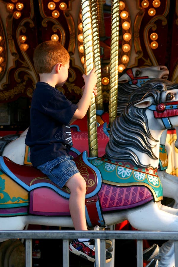 Boy Riding on Carousel stock photo. Image of game, lights - 247610