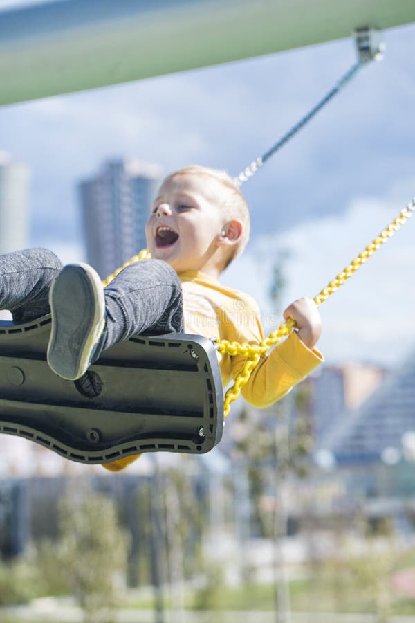 A boy is riding a swing stock photo. Image of outdoor - 145284456