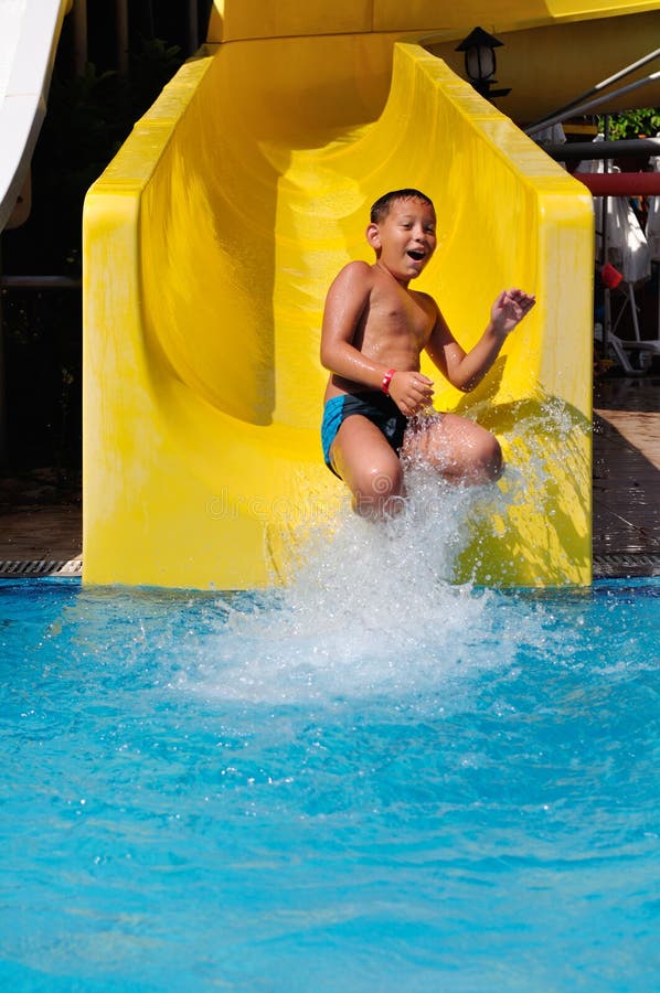Boy Splashes Down from Water Slide Stock Photo - Image of shallow, hole ...