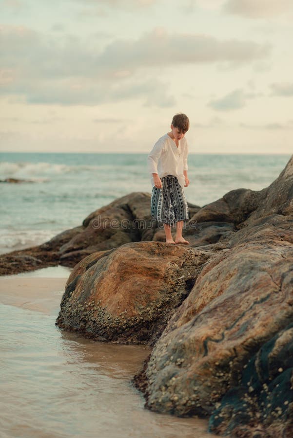 The boy on the rocks stock photo. Image of beach, play - 89181488