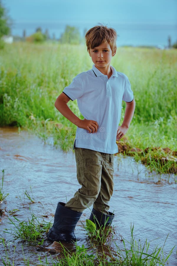 Boy in Rubber Boots Stands in the Middle of a Stream Stock Photo ...