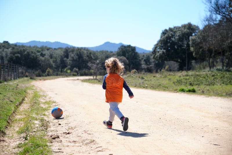 Boy Running after a Ball on a Dirt Road Stock Image - Image of nature ...