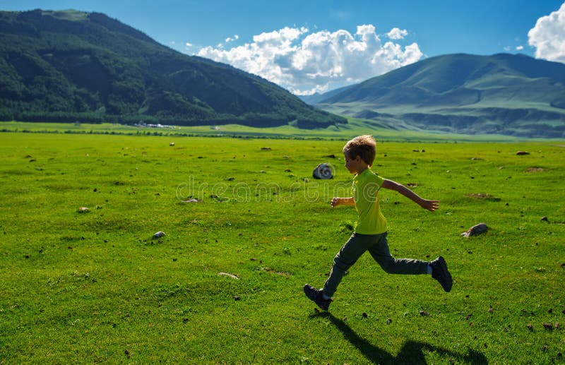 Boy Running Fast on a Green Meadow in the Mountains Stock Image - Image ...